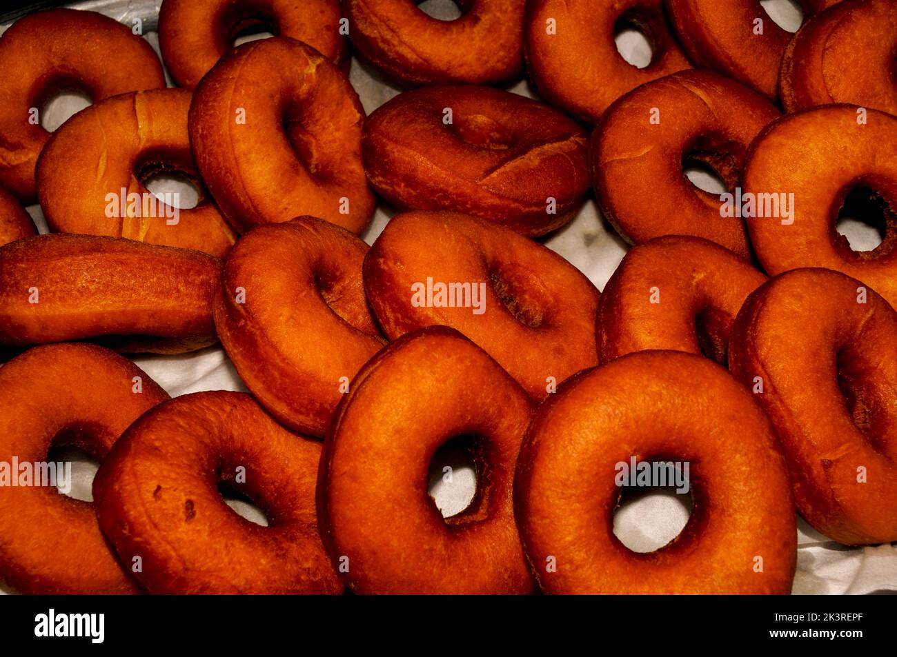 Preparation of traditional donuts. freshly fried and waiting to be ...