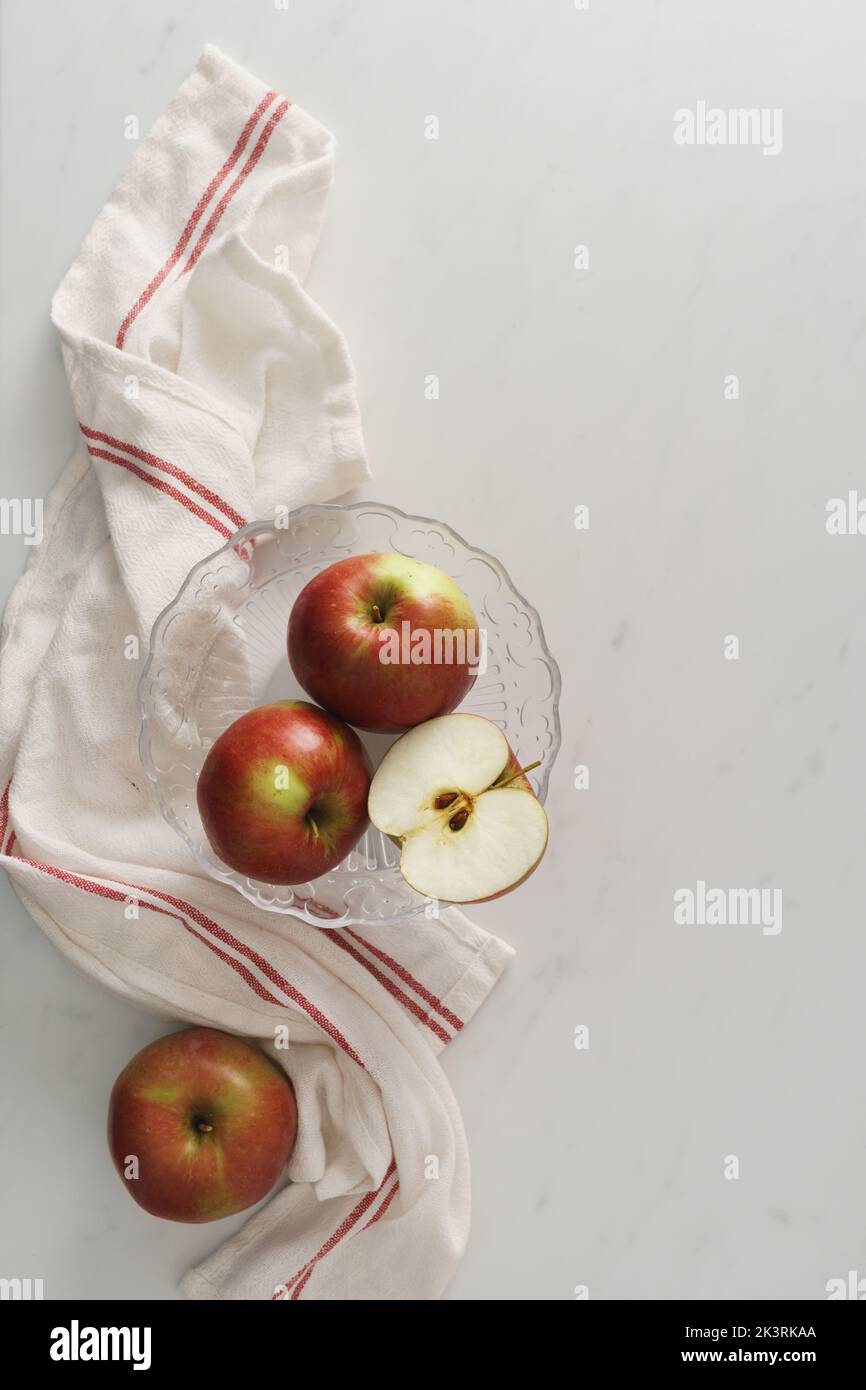 Fresh juicy apples in a bowl against a white kitchen work surface ...