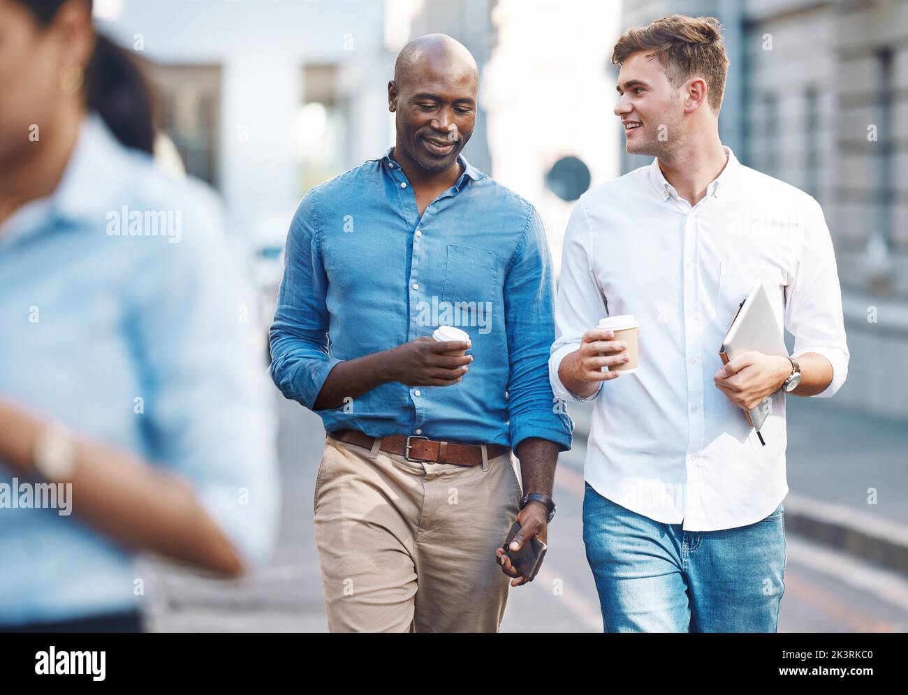Men, walk and street with takeaway coffee while talk, smile and relax ...
