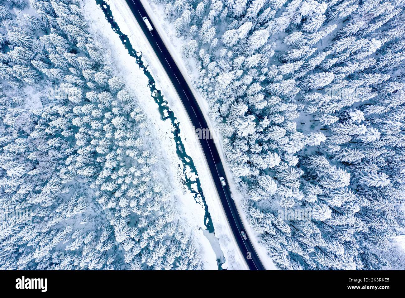Aerial view on a car driving on winter country road in snowy forest ...