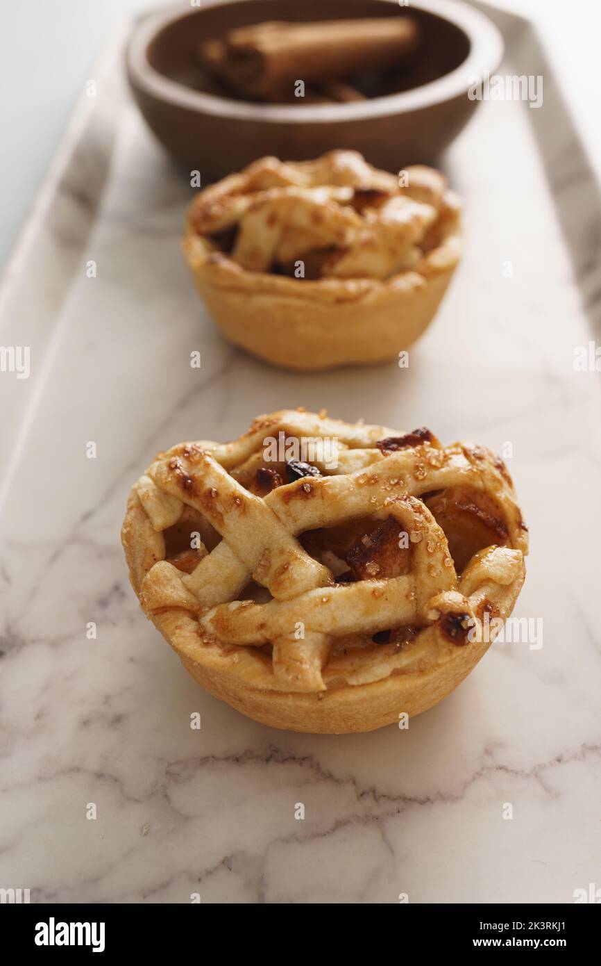 Apple and cinnamon mini pie tarts on white background. Food image with ...