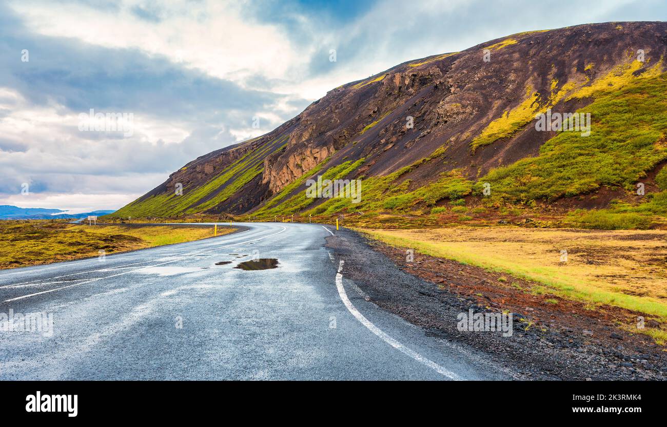 In The Middle Of A Wide Open Empty Road Surrounded By Mountains In ...