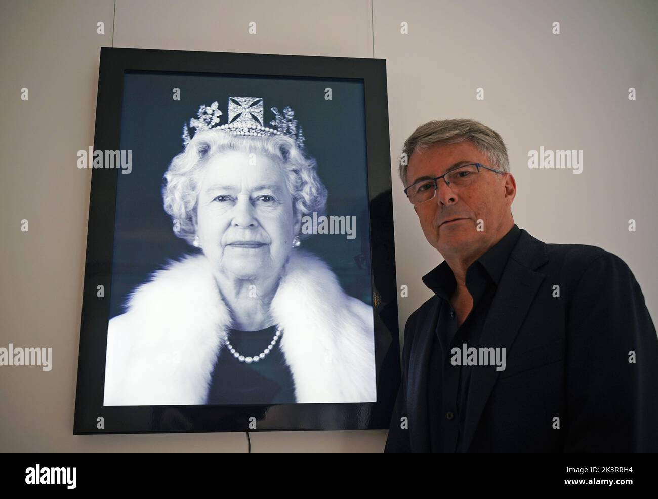 Rob Munday poses next to a piece by Munday in collaboration with Chris Levine, Equanimity: Queen ...