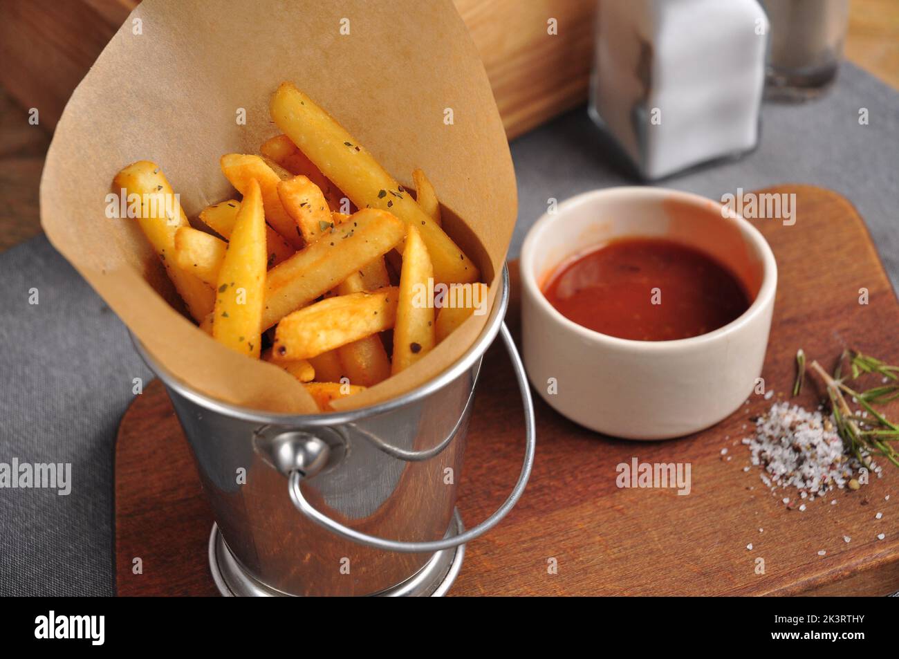tasty French fries in a metal bucket with tomato sauce Stock Photo - Alamy