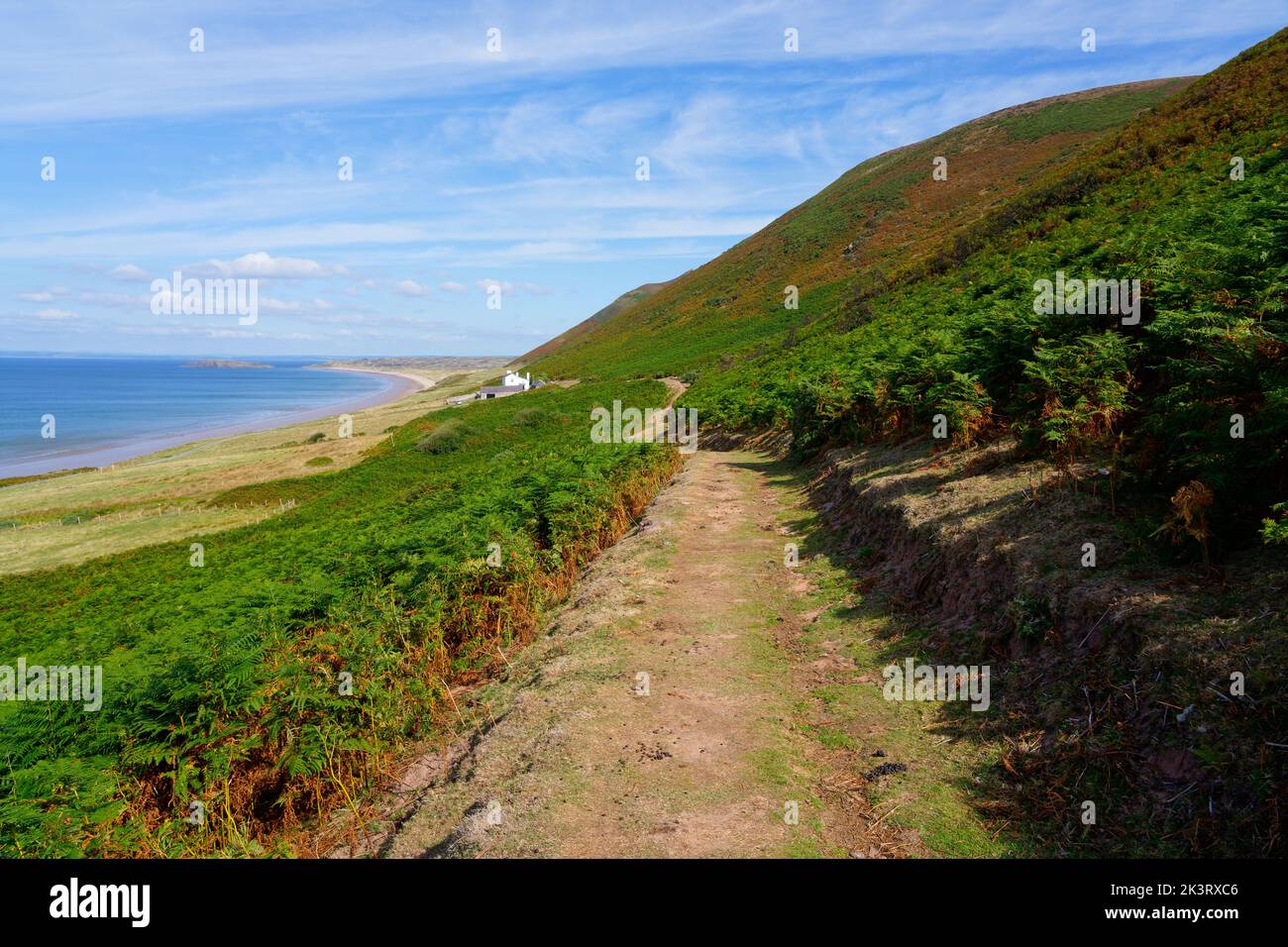 Rugged, winding path across the slopes of Rhossili Bay, past a distant ...