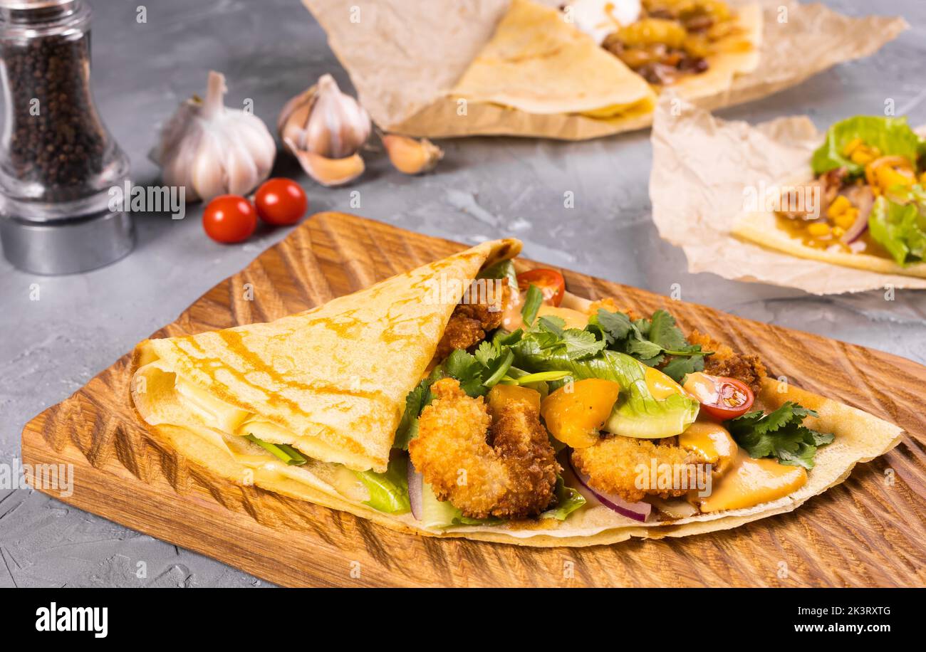 Pancake or crepe with fried shrimp tomatoes and vegetables and cheese Stock Photo - Alamy