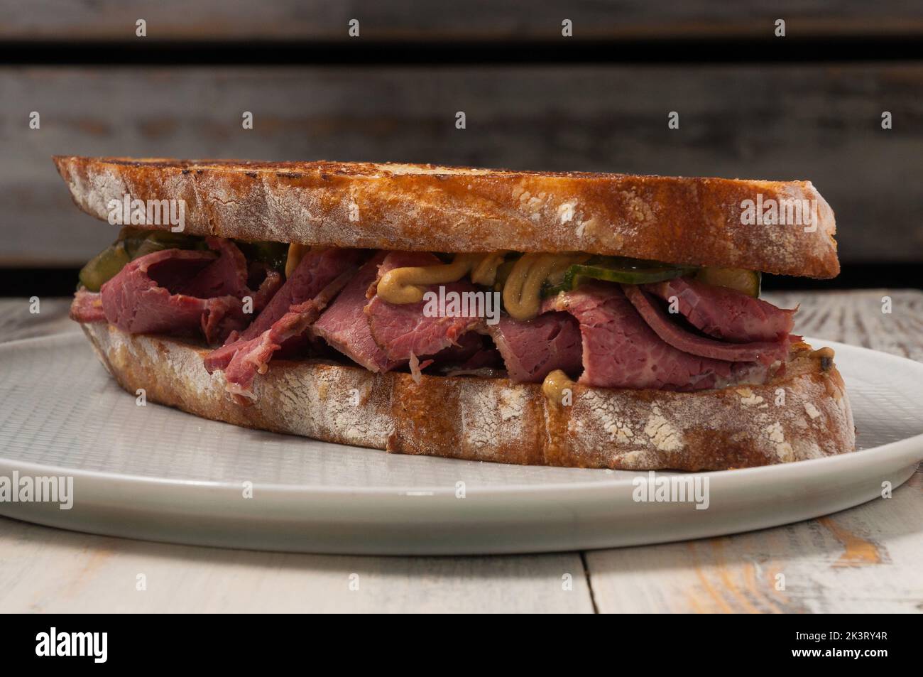 ciabatta sandwich with beef, cucumber and mustard sauce. End view ...