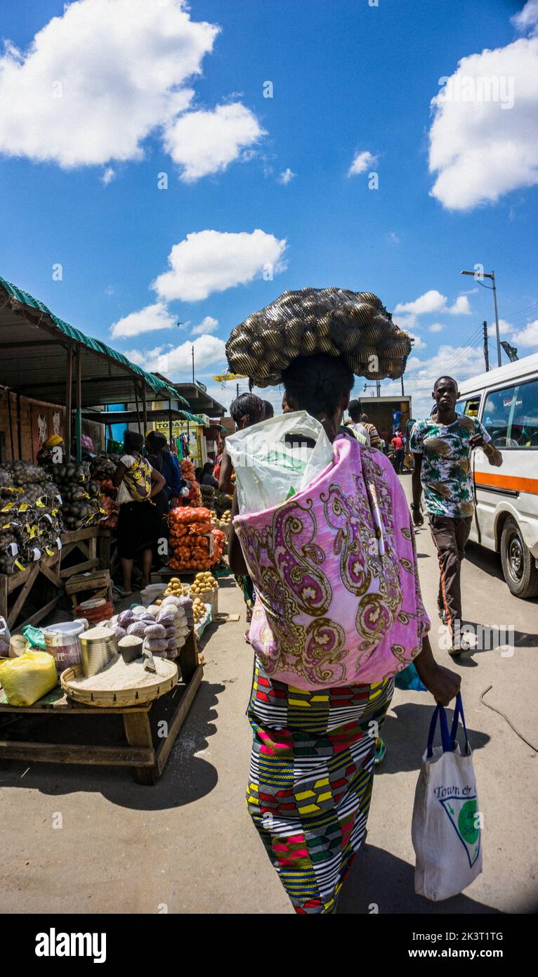 African woman carrying sack on her head and bag on her back Stock Photo ...