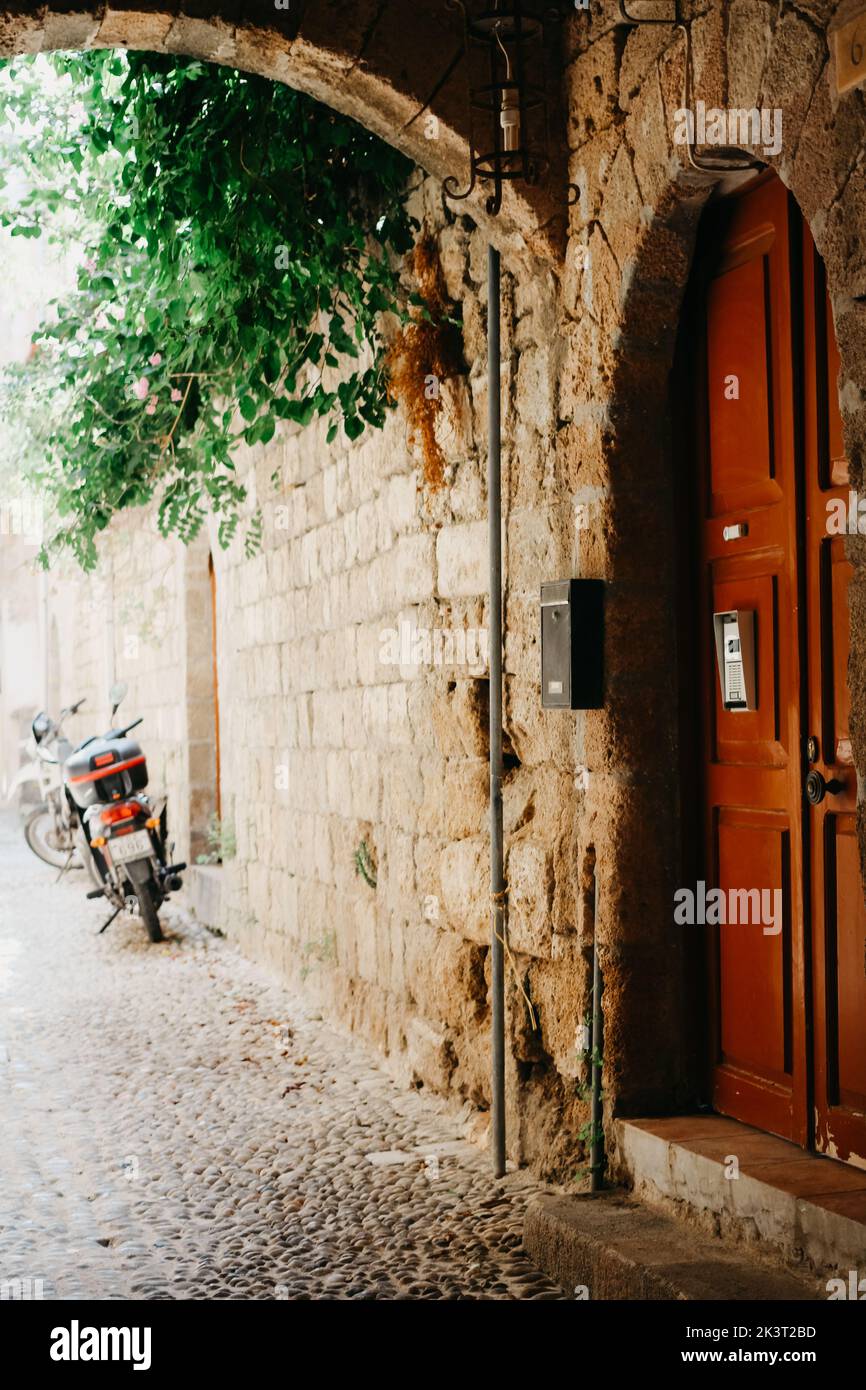 A vertical shot of a moped parked in the downtown area of traditional ...