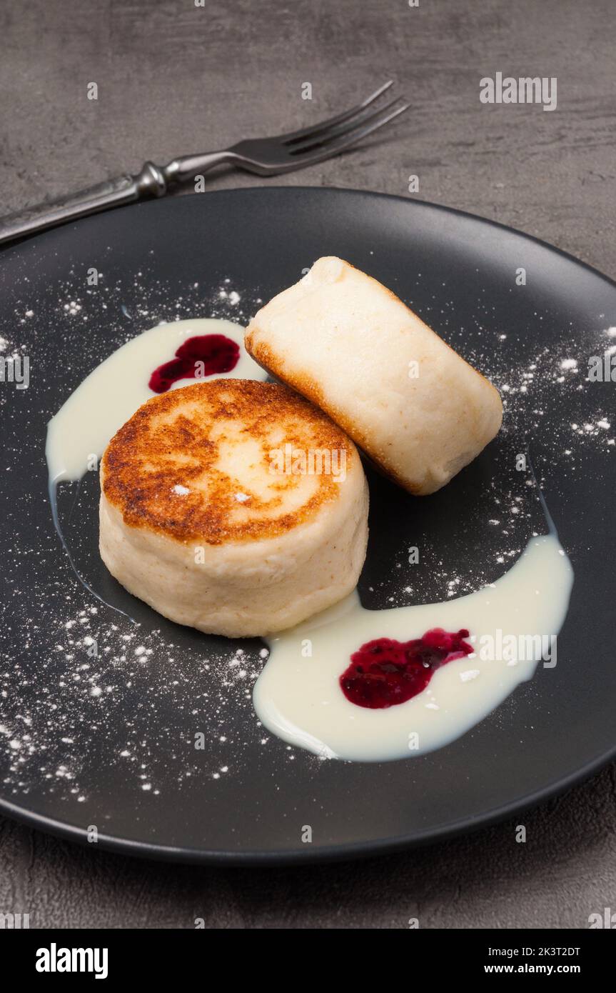 sweet cheesecakes with condensed milk and jam on a dark plate Stock ...