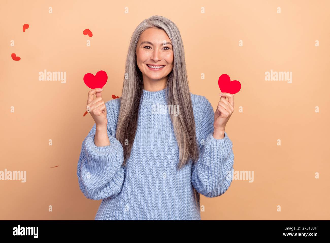 Photo of dreamy cute lady pensioner dressed blue pullover holding two ...
