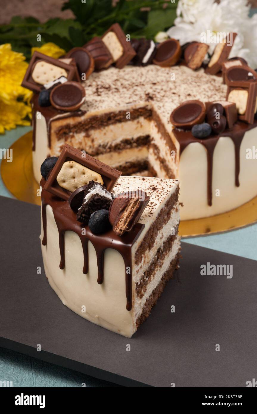 the sweet cut cake is decorated with milk chocolate cubes and berries ...