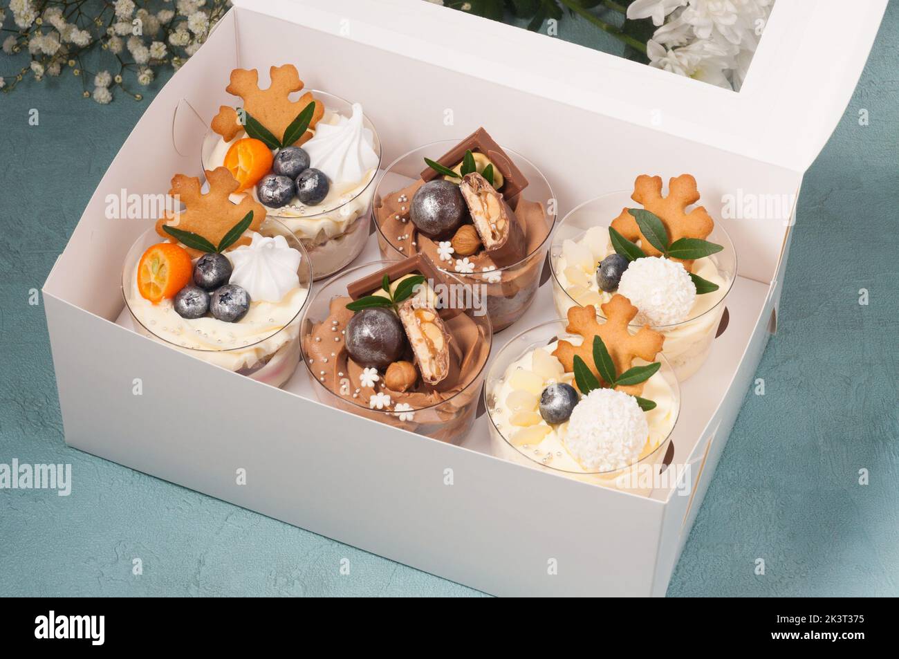 a sweet set of desserts in plastic cups decorated with chocolate and ...
