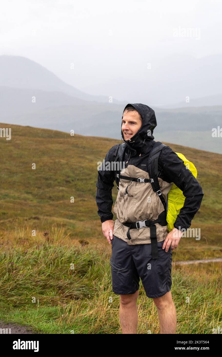 Hiker in the Scottish highlands. Wearing raincoat Stock Photo - Alamy