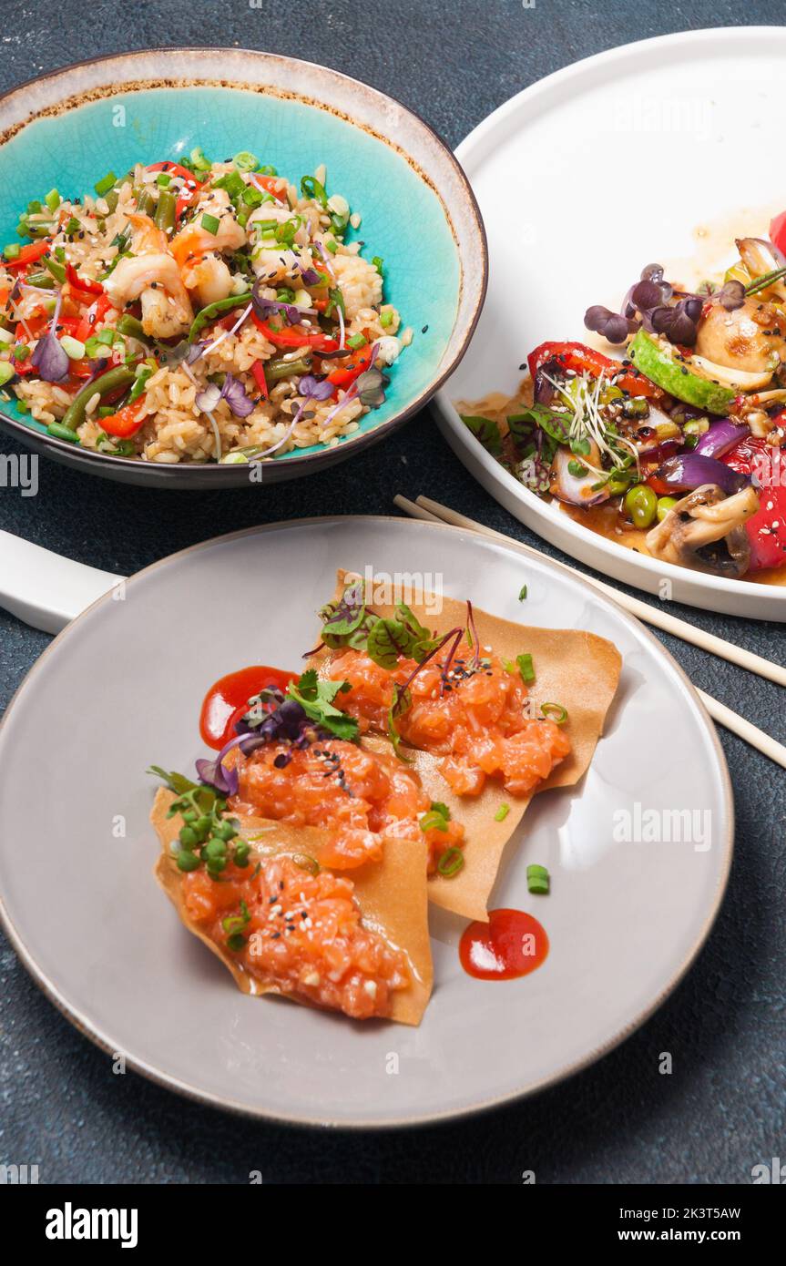 tasty assorted Asian food: rice with shrimp, baked vegetables and chips ...