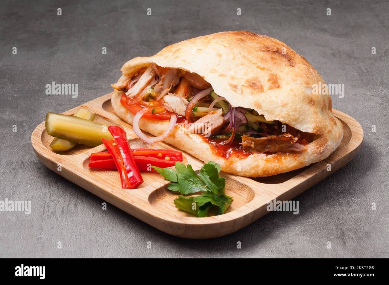 tasty doner kebab with chicken and vegetables, pickled cucumber and hot ...
