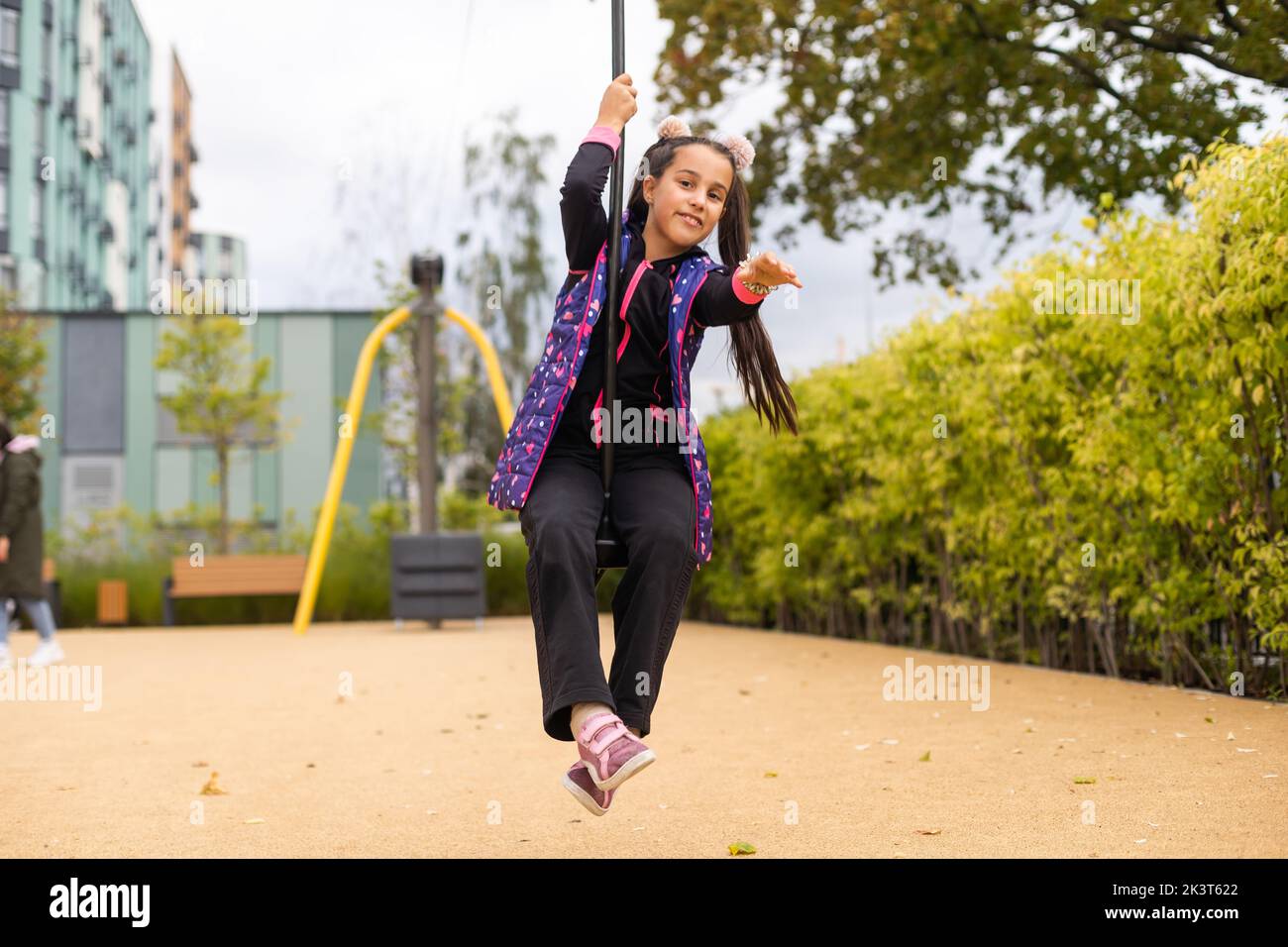 Little girl rides on Flying Fox play equipment. Child girl is smiling ...