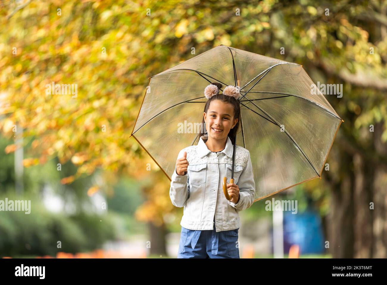 Kid playing out in the rain. Children with umbrella play outdoors in ...