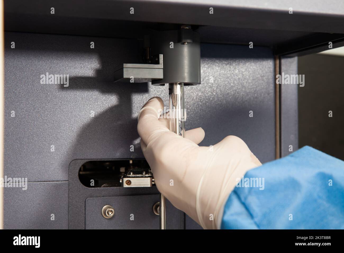 Scientist loading a test tube containing a patient sample on the flow ...