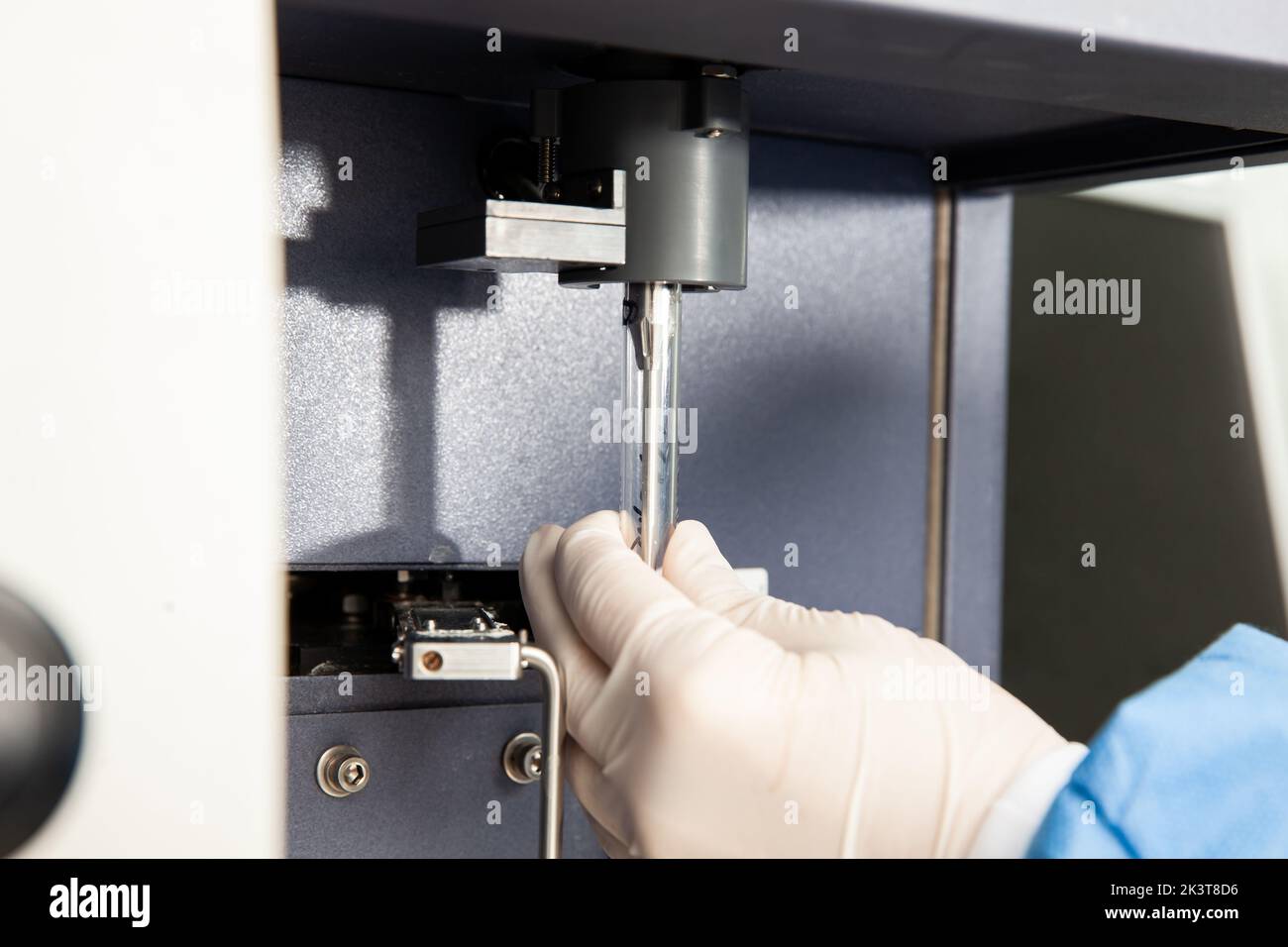 Scientist loading a test tube containing a patient sample on the flow ...