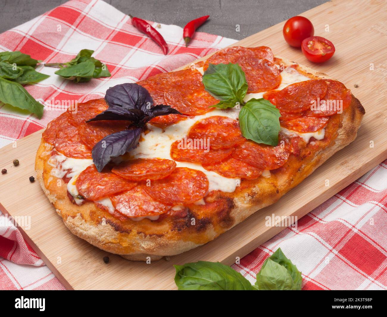 tasty pepperoni pizza on Roman dough on a wooden board Stock Photo - Alamy