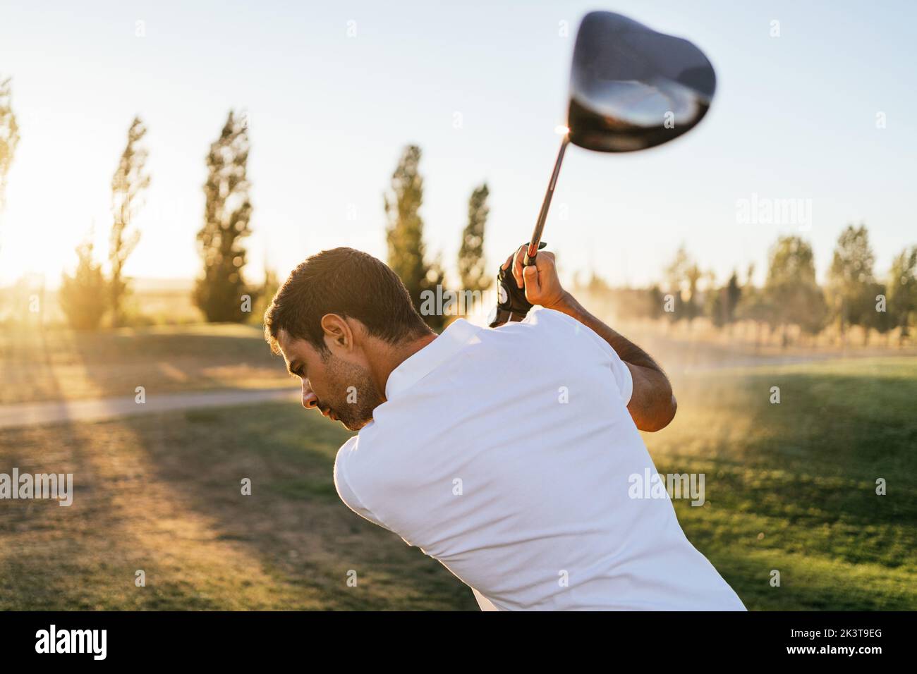 Professional male golf player preparing to hit ball with putter in ...