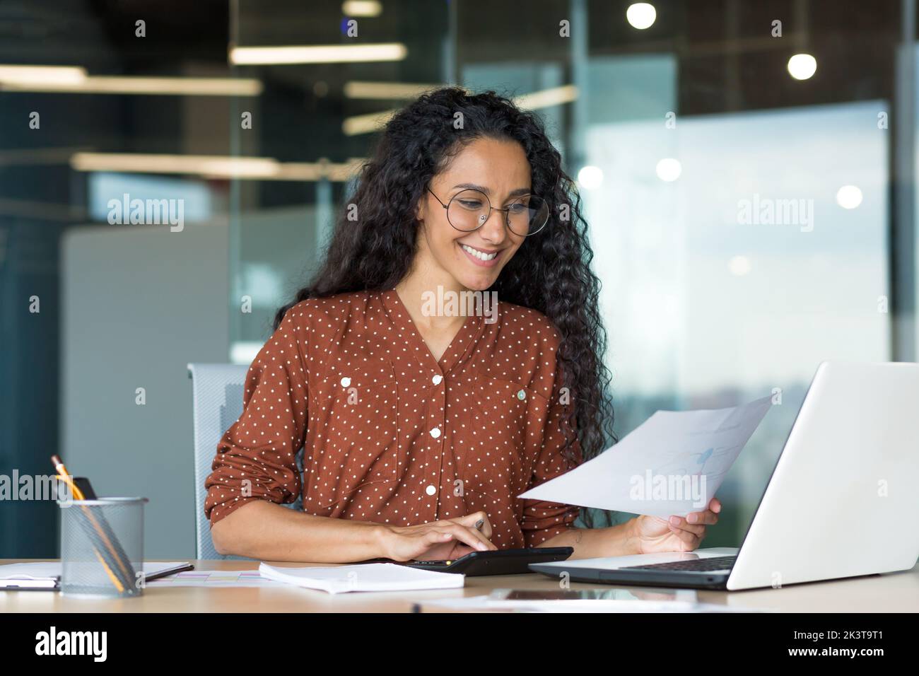 Young successful businesswoman behind paperwork, Hispanic woman working ...