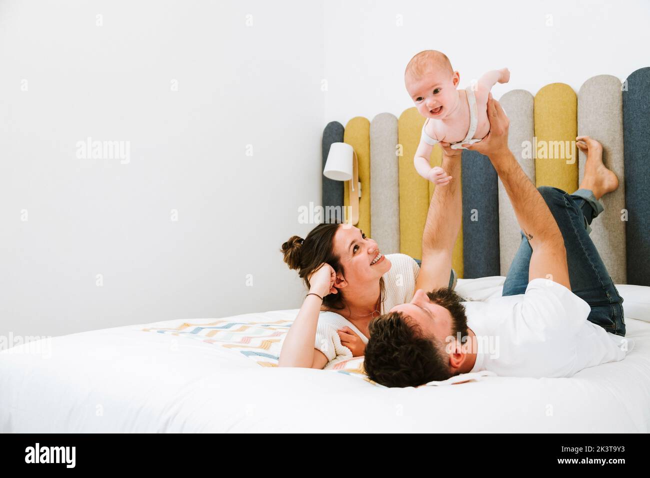 Father pretending that playful baby flying like superhero while ...