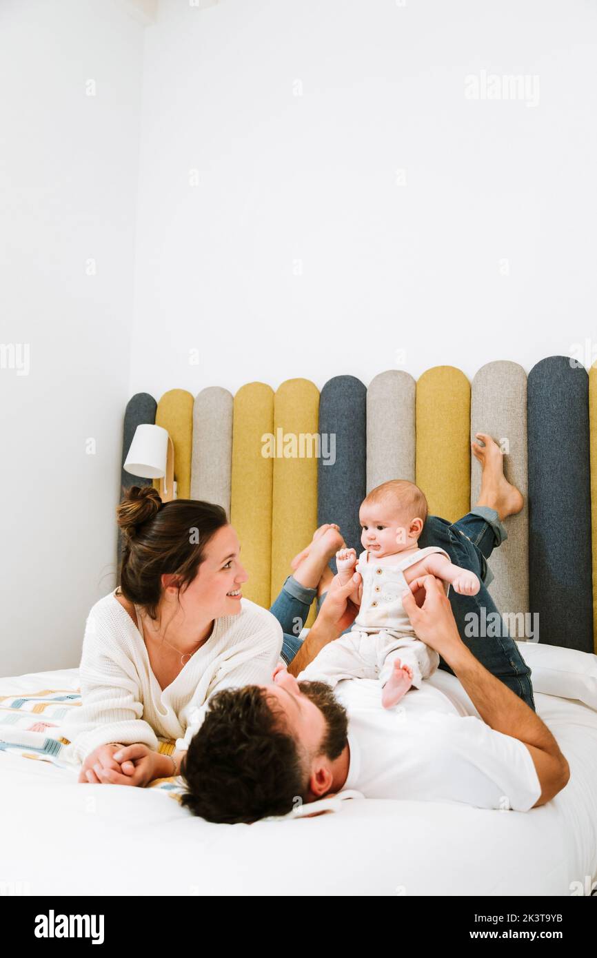 Playful father playing with baby while chilling together with wife and ...