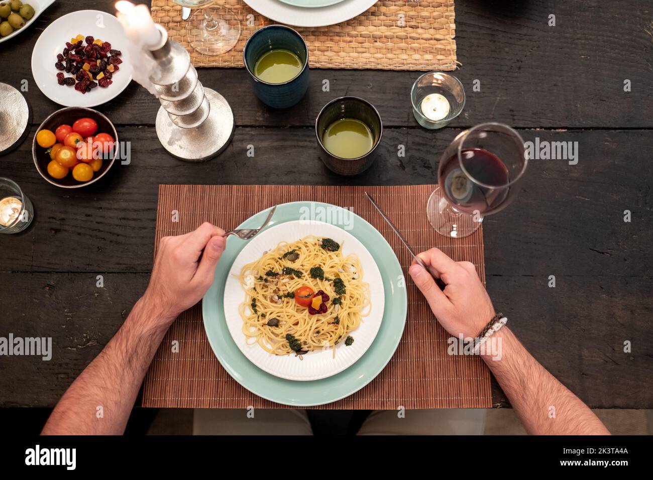 Top view of crop male eating delicious homemade pasta while sitting at ...
