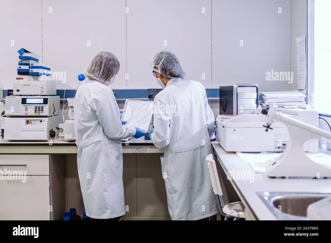 Young women standing with papers and in laboratory Stock Photo - Alamy