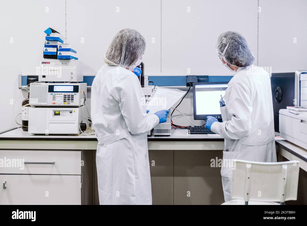 Rear view of two young doctors at computer in laboratory Stock Photo ...