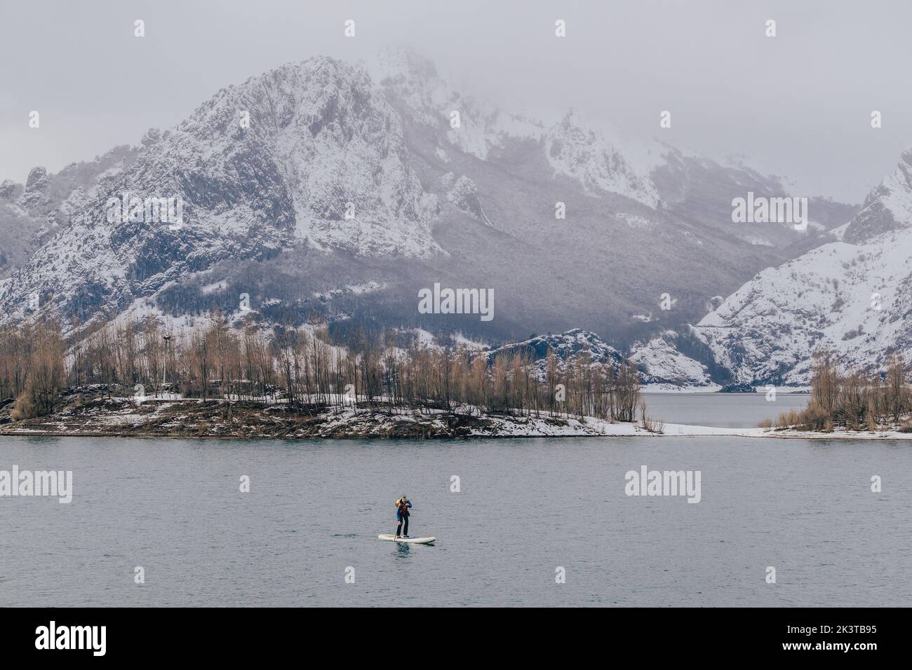 Tourist floating on sup between water surface and picturesque view of ...