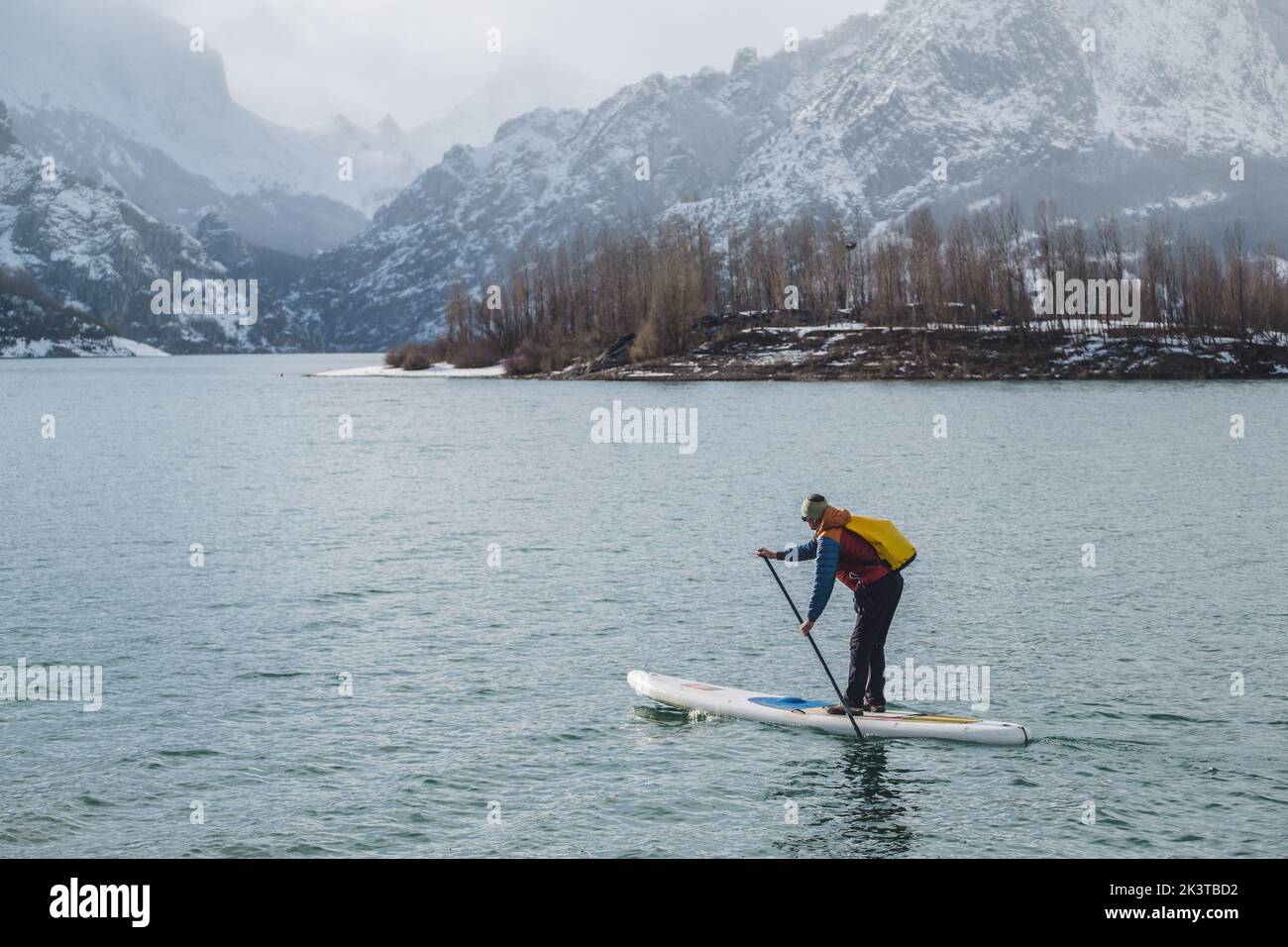 Tourist floating on sup between water surface and picturesque view of ...