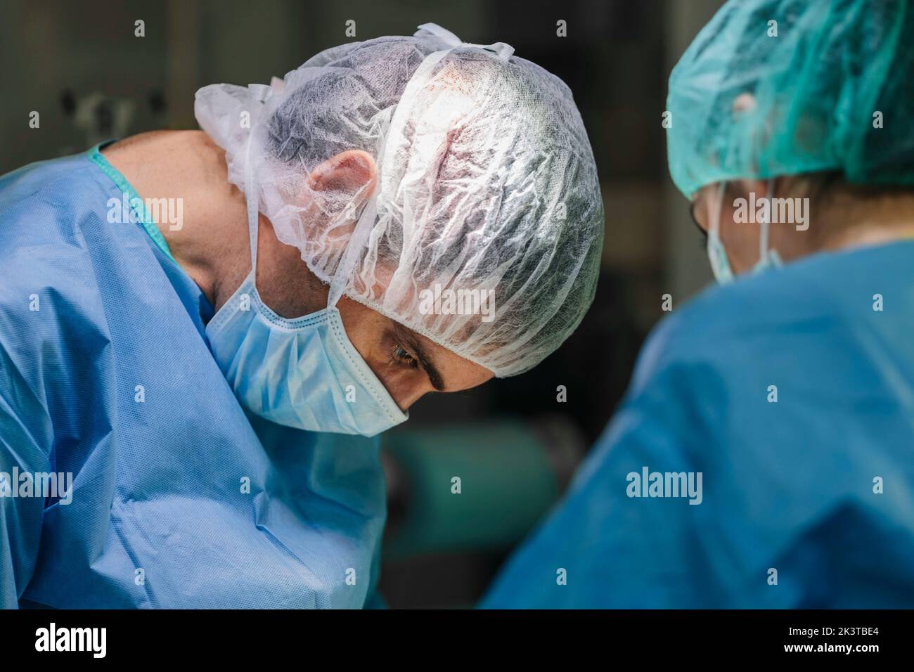 Crop side view of serious and concentrated male doctor working in light ...