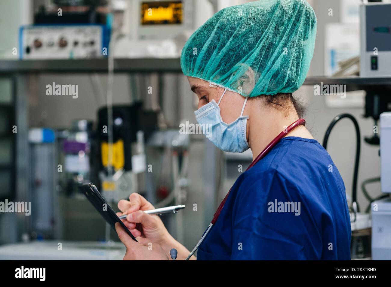 Side view of young female veterinary in medical mask and uniform ...