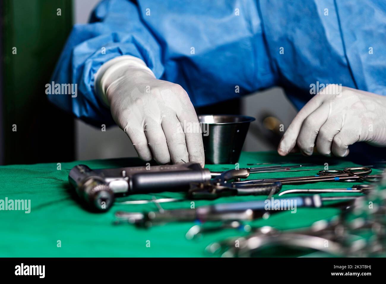 Doctor with assistant in uniform and latex gloves using surgical ...