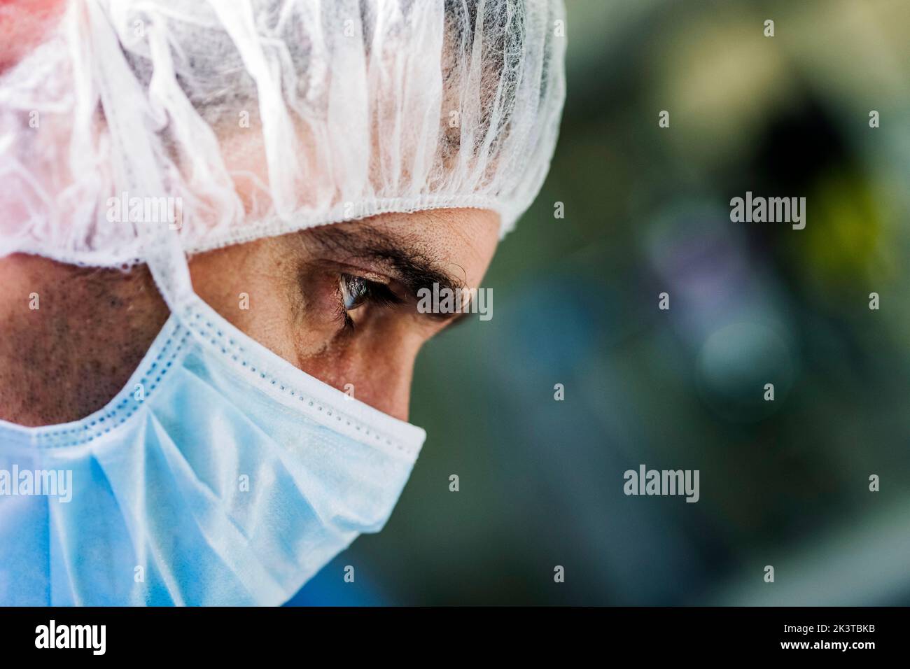 Crop side view of serious and concentrated male doctor working in light ...