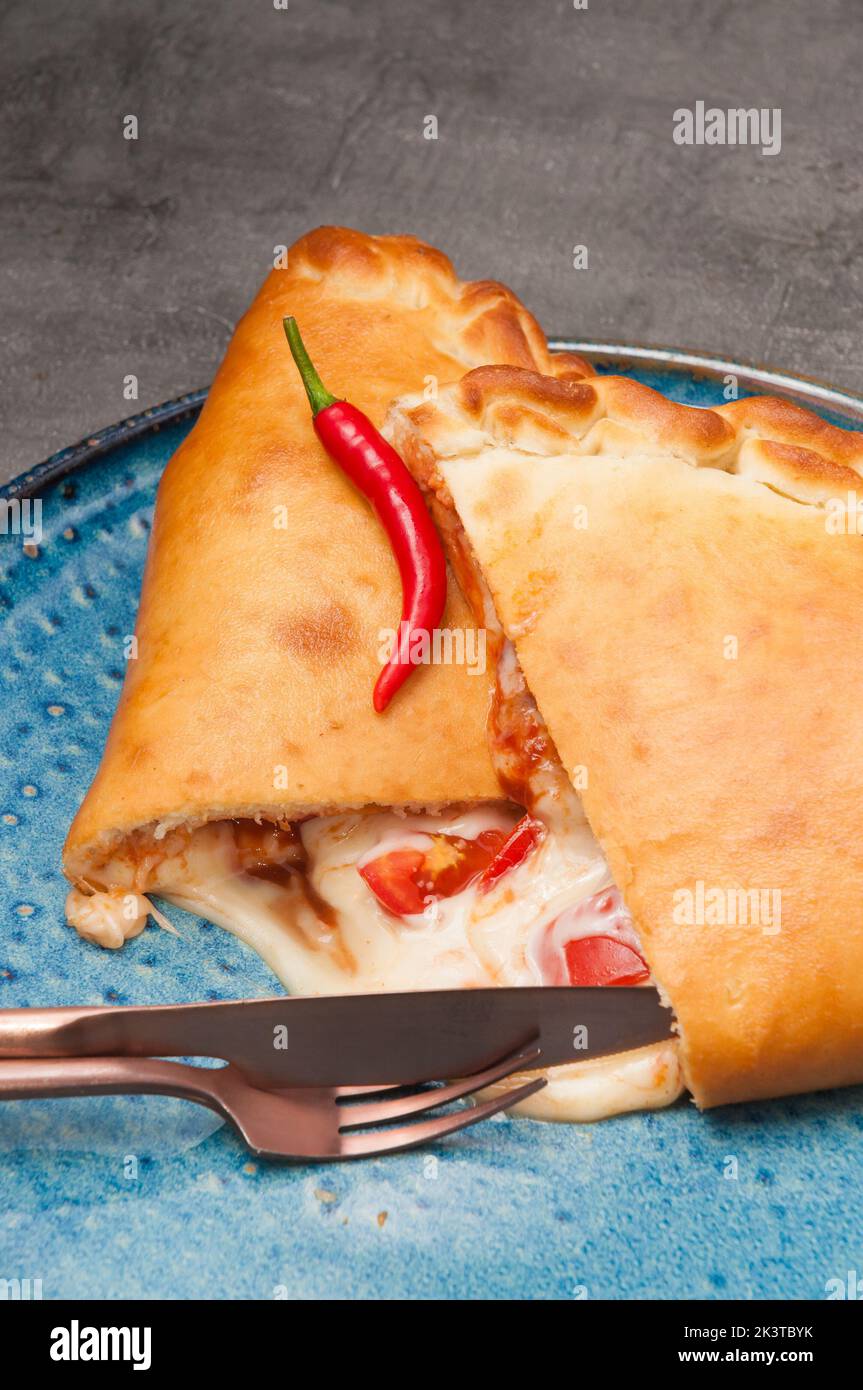 tasty hot pizza calzone with mozzarella and tomatoes Stock Photo - Alamy