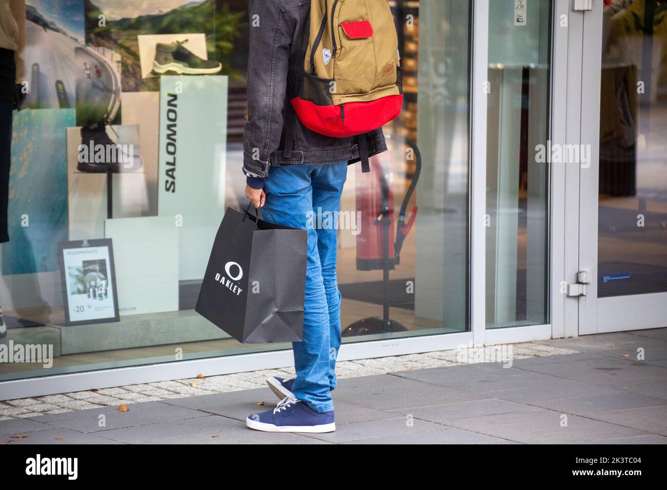 Symbol image of shopping: A man stands with a shopping bag in front of ...