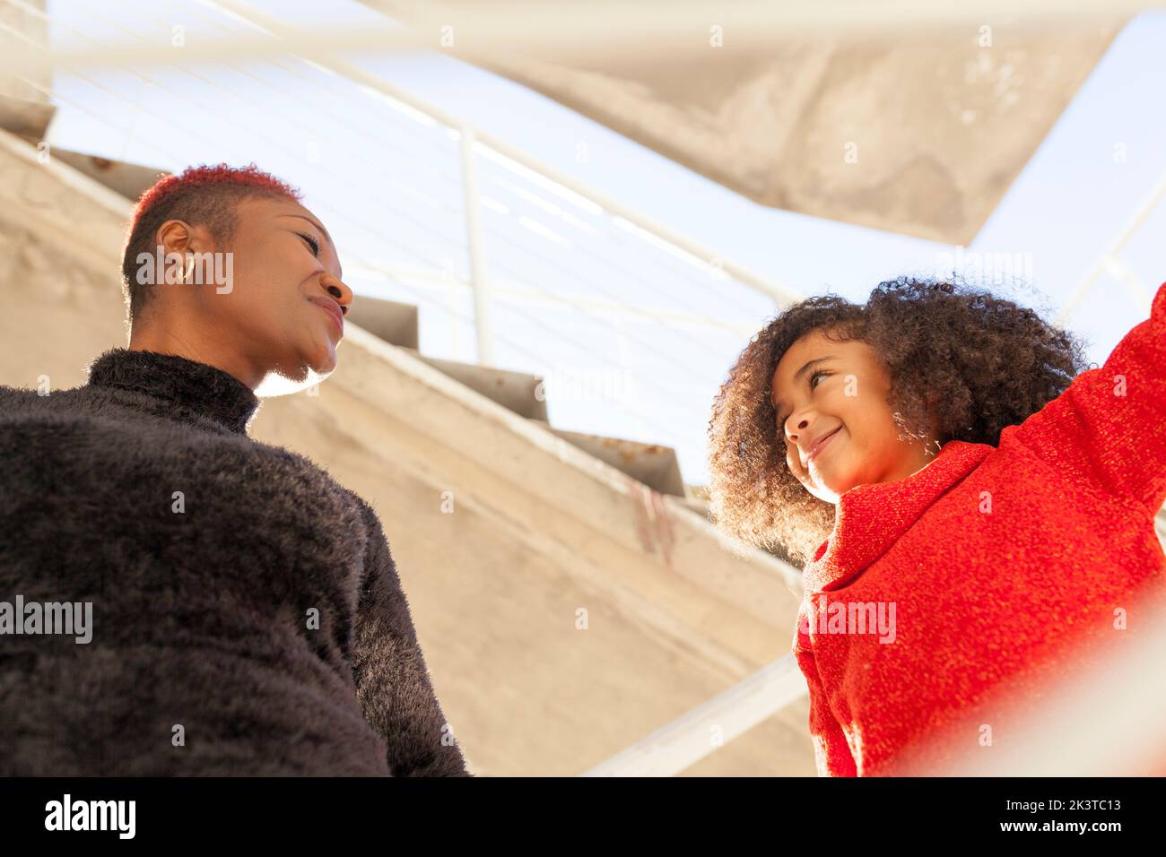 from below Smiling cute black girl near woman on steps Stock Photo - Alamy