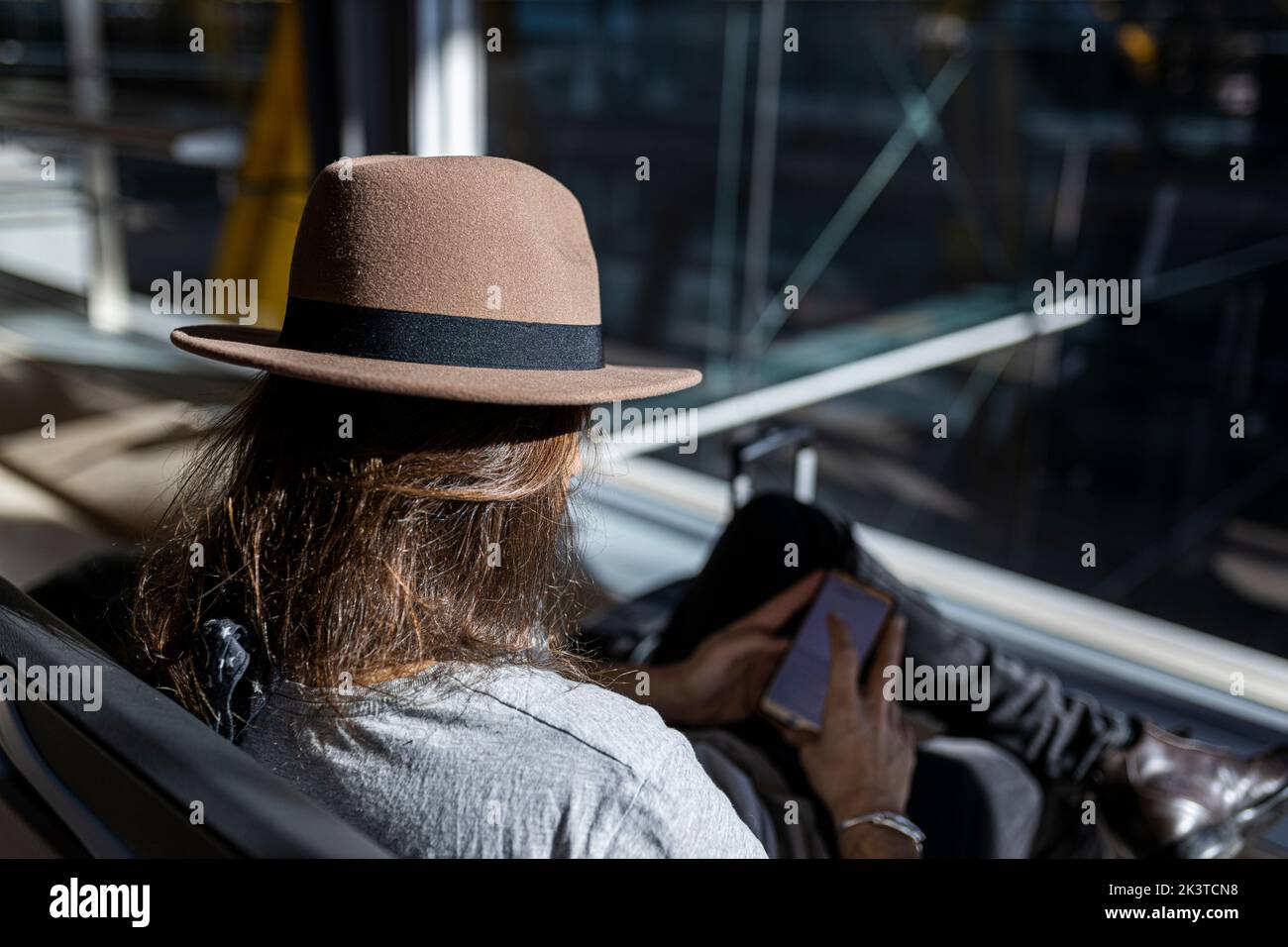 Back view of unrecognizable focused man with long hair in stylish ...