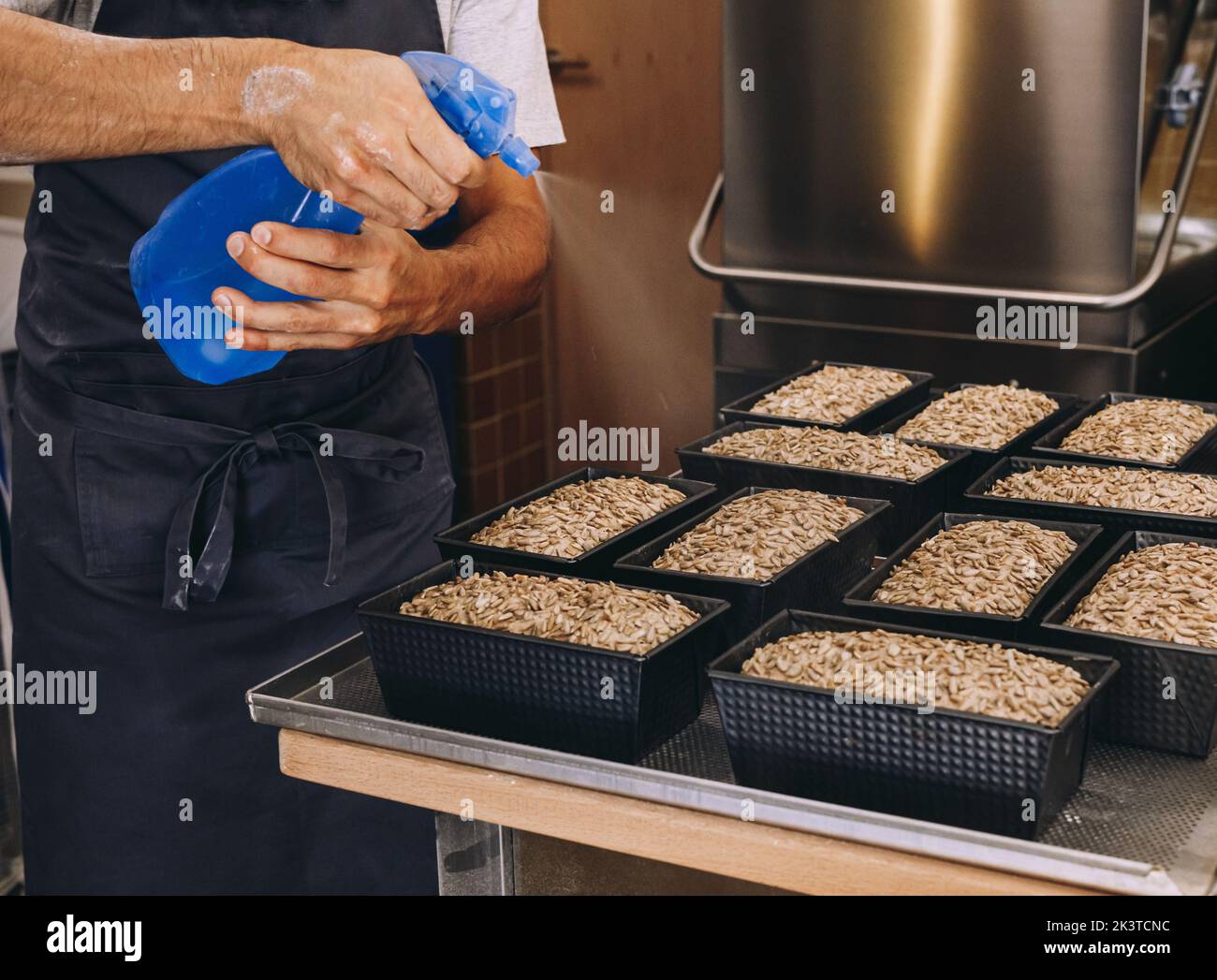 Unrecognizable male baker in apron standing in bakery kitchen and ...
