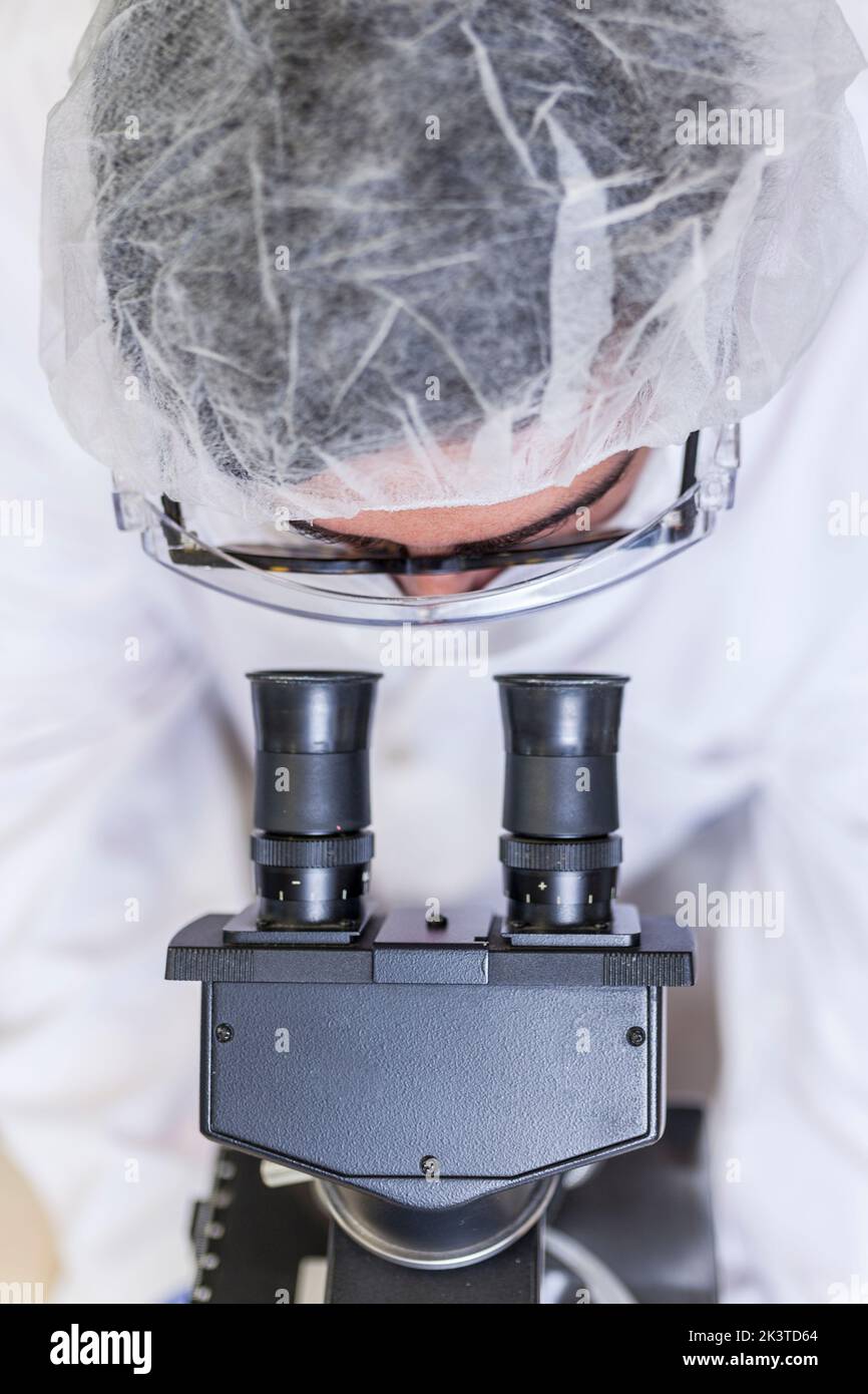 Top view of man scientist looking through microscope at laboratory ...