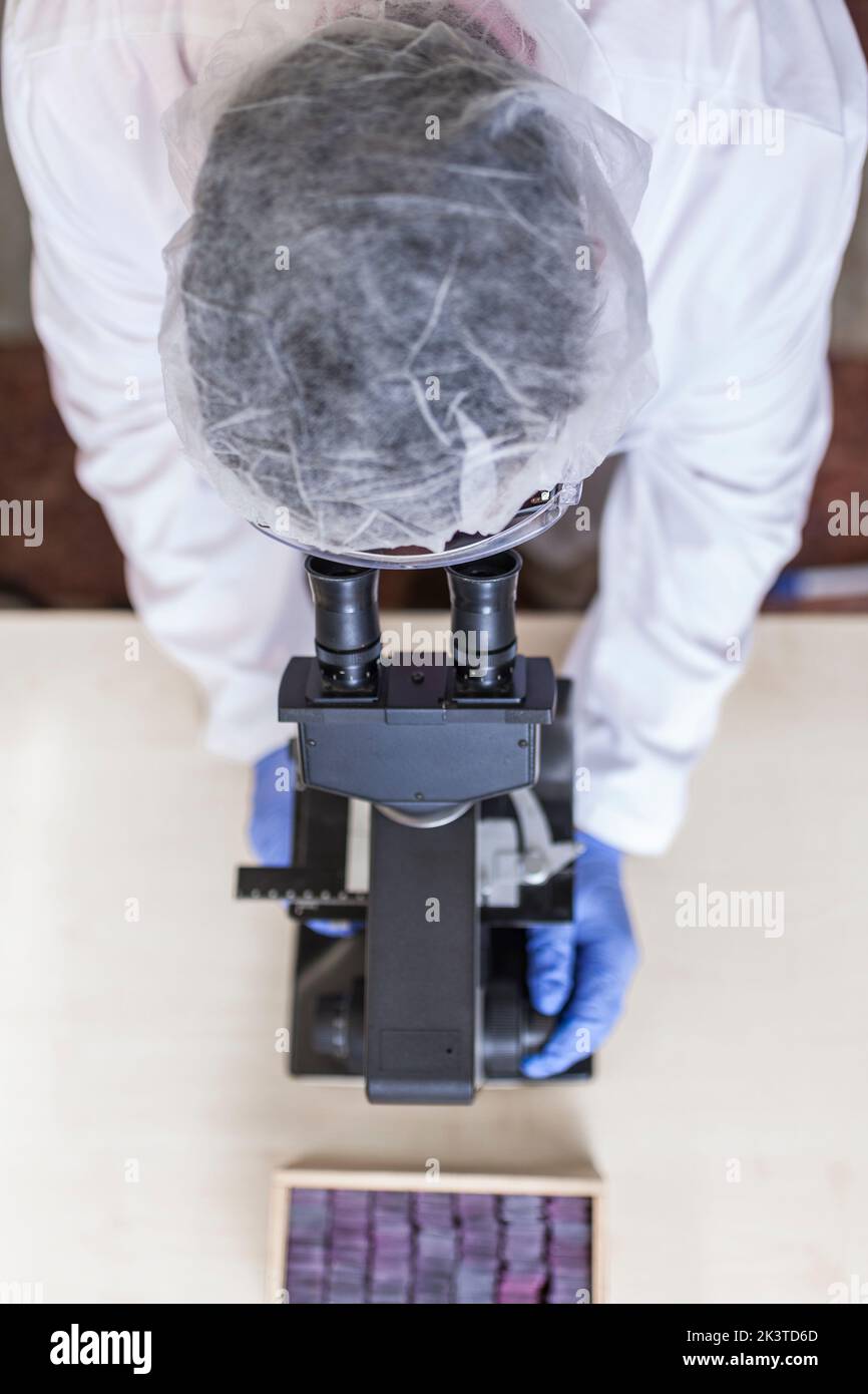 Top view of man scientist looking through microscope at laboratory ...