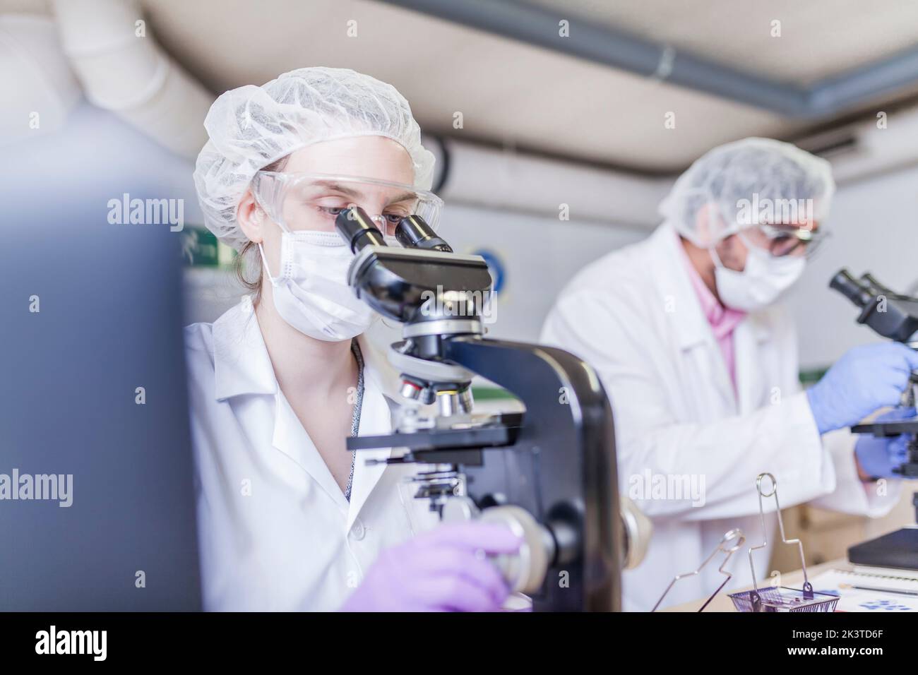 woman and man scientists looking through microscope at laboratory Stock ...