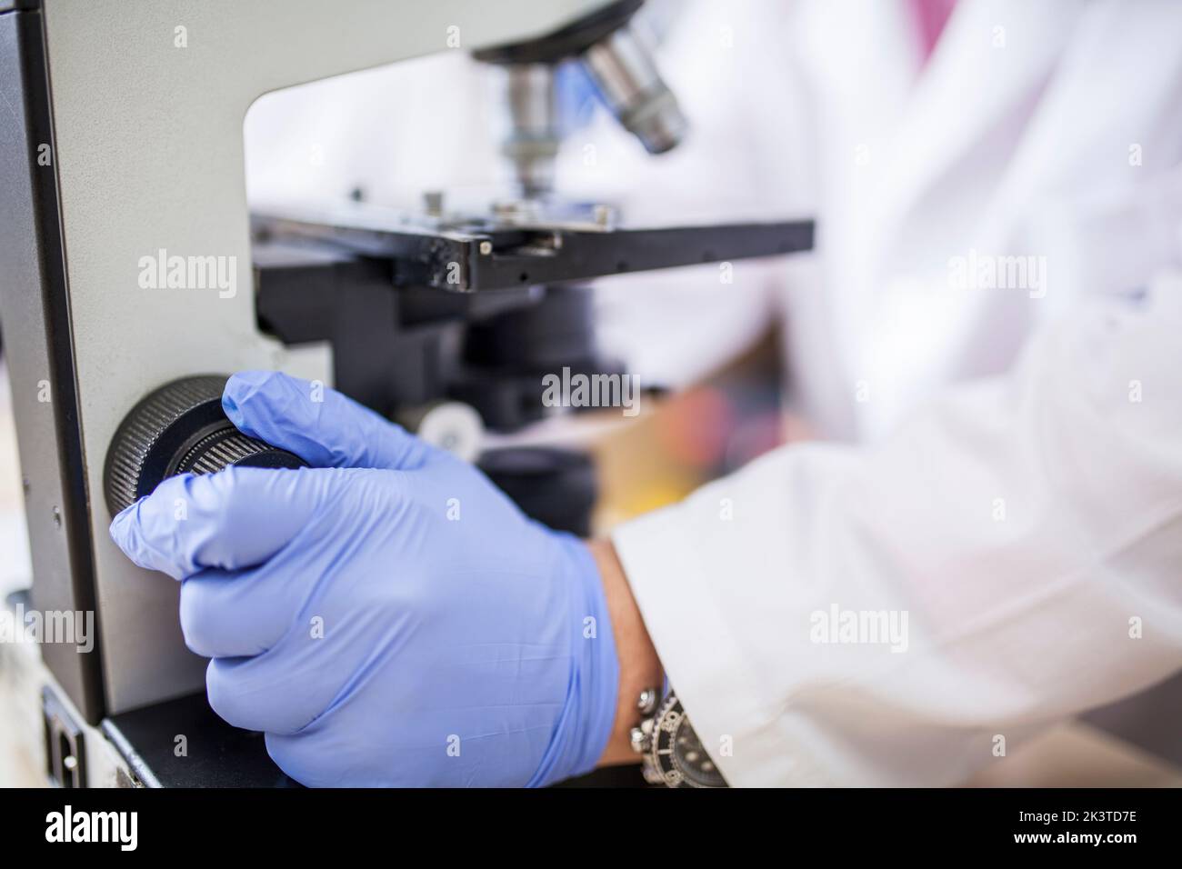 close-up side view of hand of anonymous scientist adjusting a microscope at laboratory Stock ...