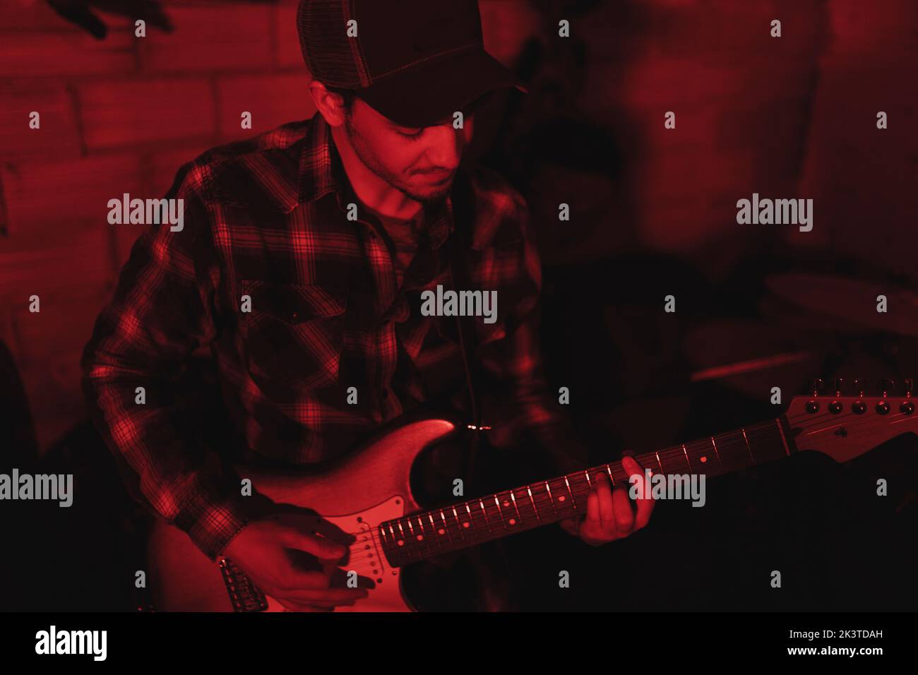 Group of musicians playing in red neon lights at music studio Stock ...