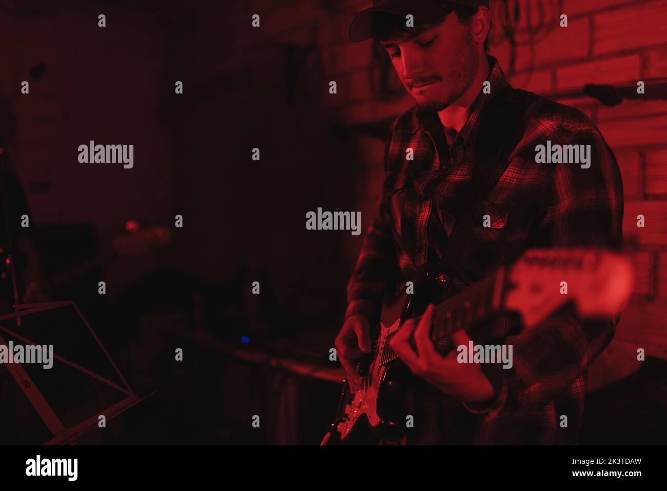 Group of musicians playing in red neon lights at music studio Stock ...