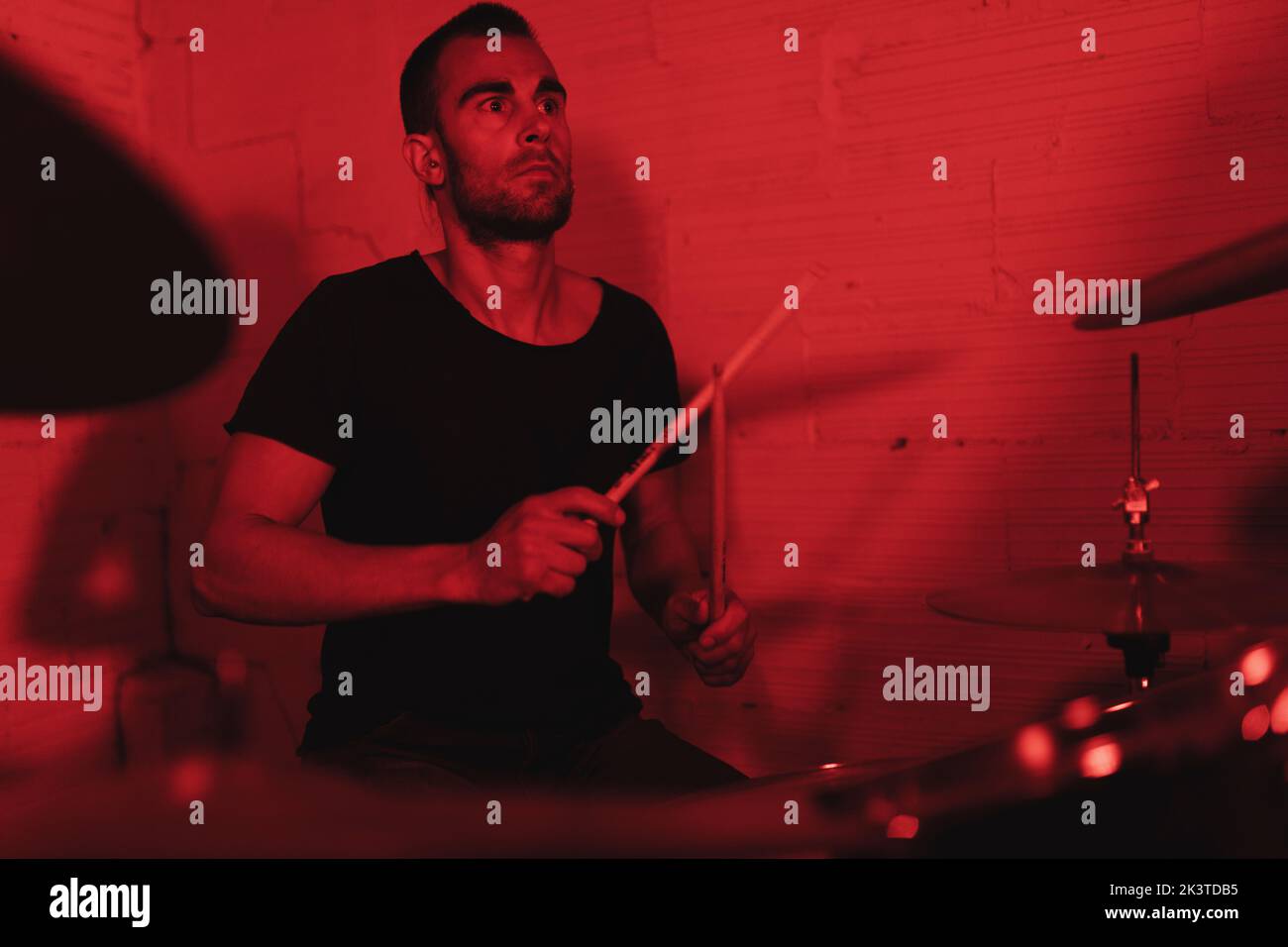 Group of musicians playing in red neon lights at music studio Stock ...